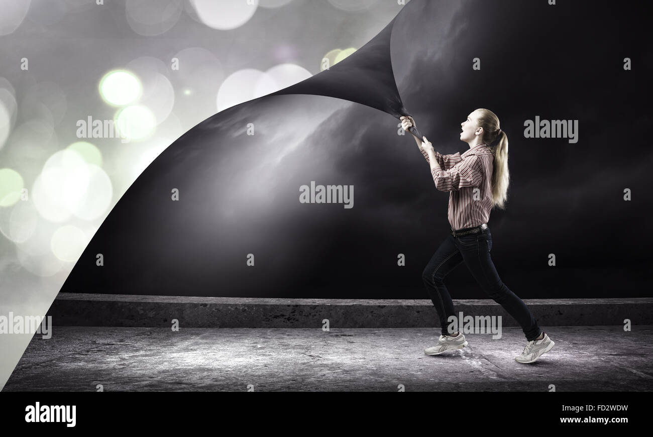 Young woman pulling page to change scene Stock Photo - Alamy