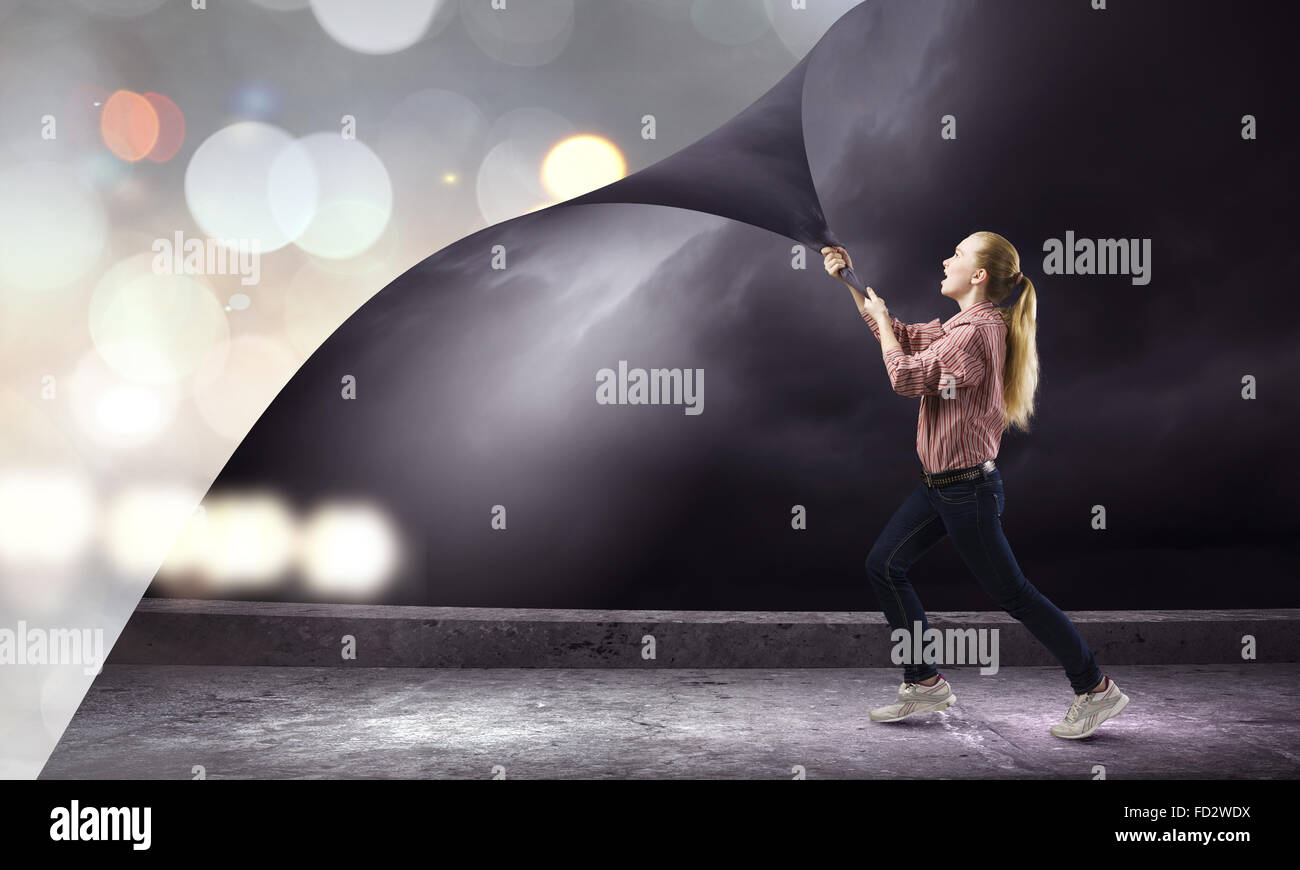 Young woman pulling page to change scene Stock Photo - Alamy