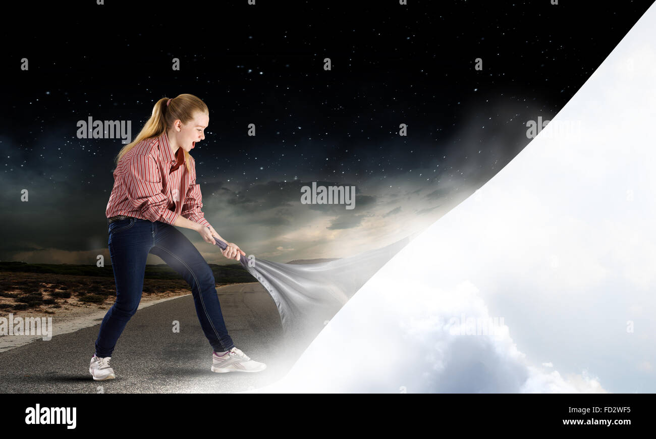 Young woman pulling page to change scene Stock Photo - Alamy