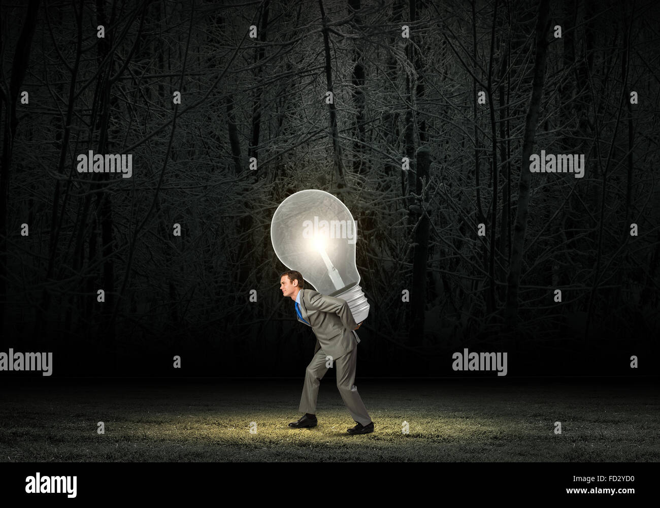 Young businessman carrying light bulb on back Stock Photo - Alamy