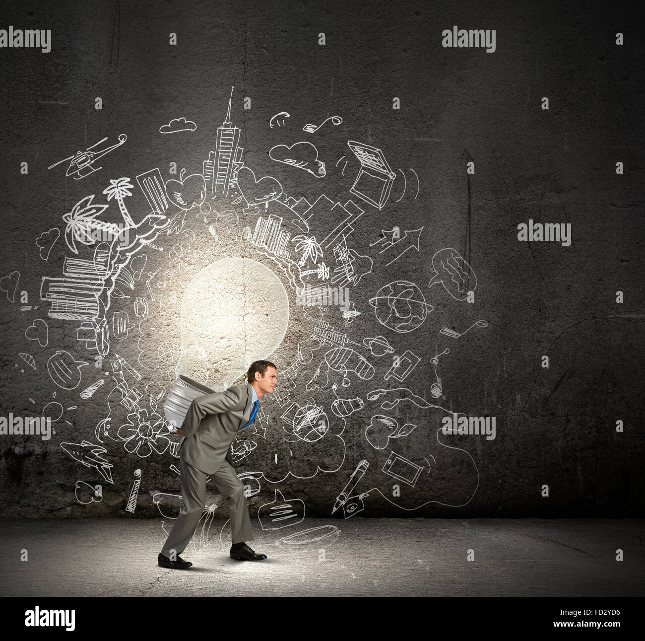 Young businessman carrying light bulb on back Stock Photo - Alamy