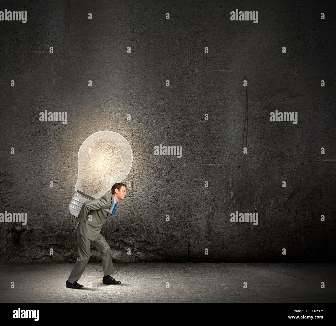 Young businessman carrying light bulb on back Stock Photo - Alamy