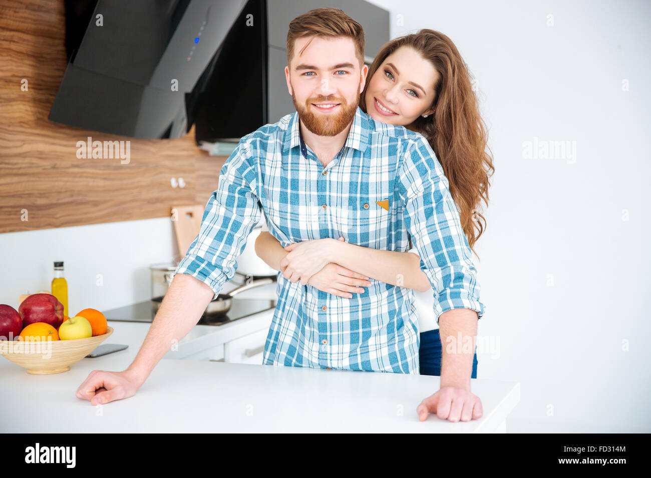 Portrait of a smiling young couple hugging in the kitchen at home Stock ...