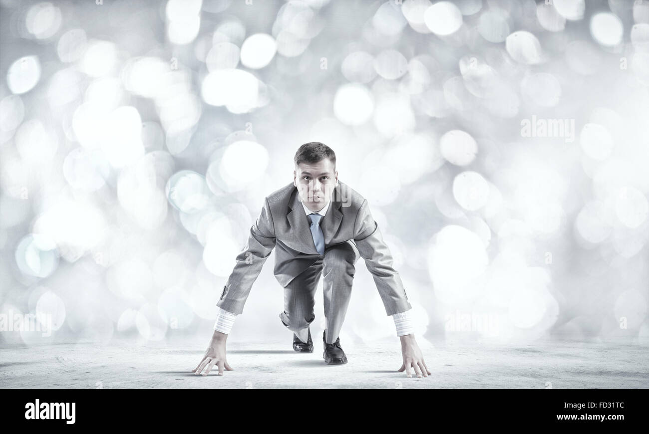 Young businessman standing in start pose ready to run Stock Photo - Alamy
