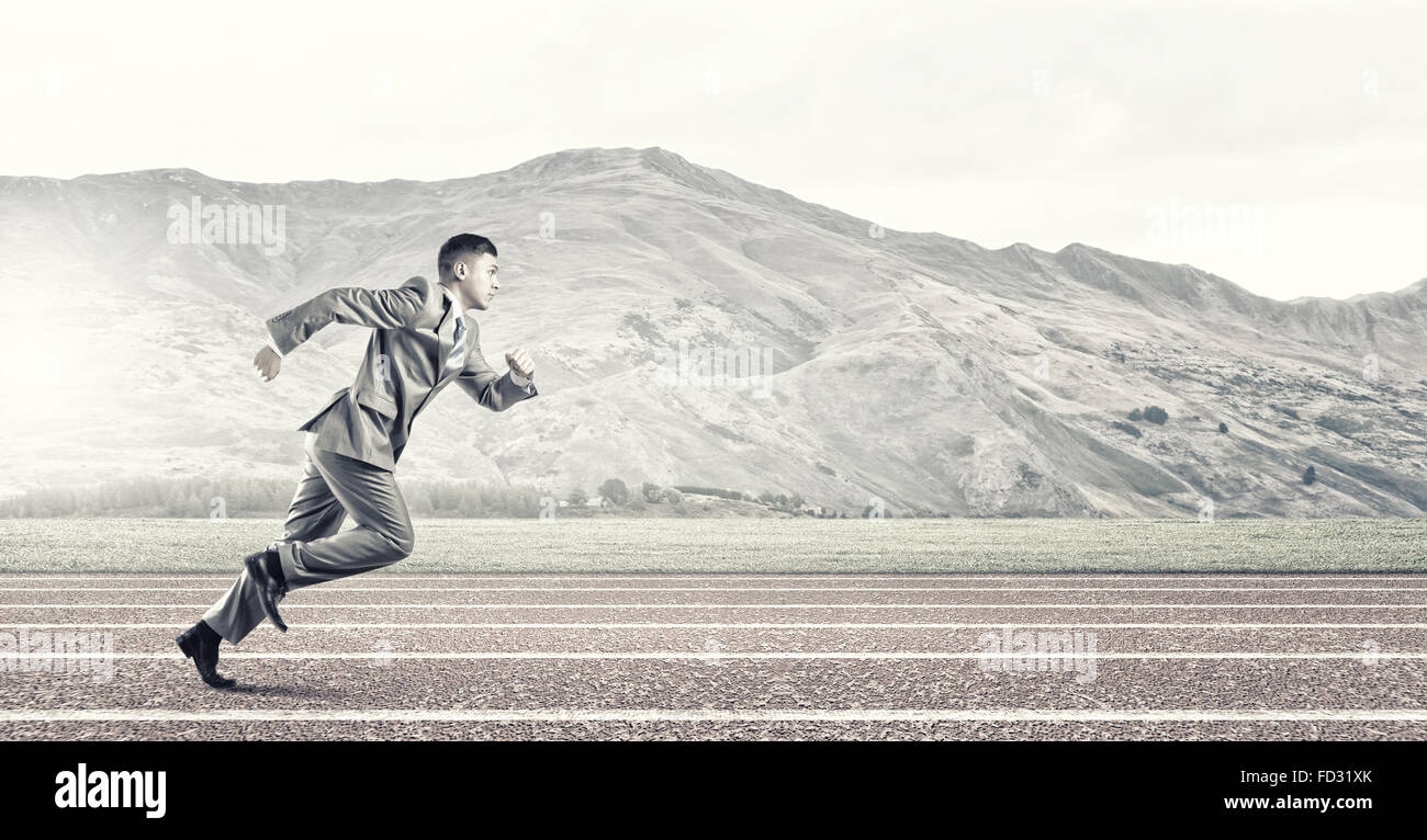 Young businessman in suit running on stadium track Stock Photo - Alamy