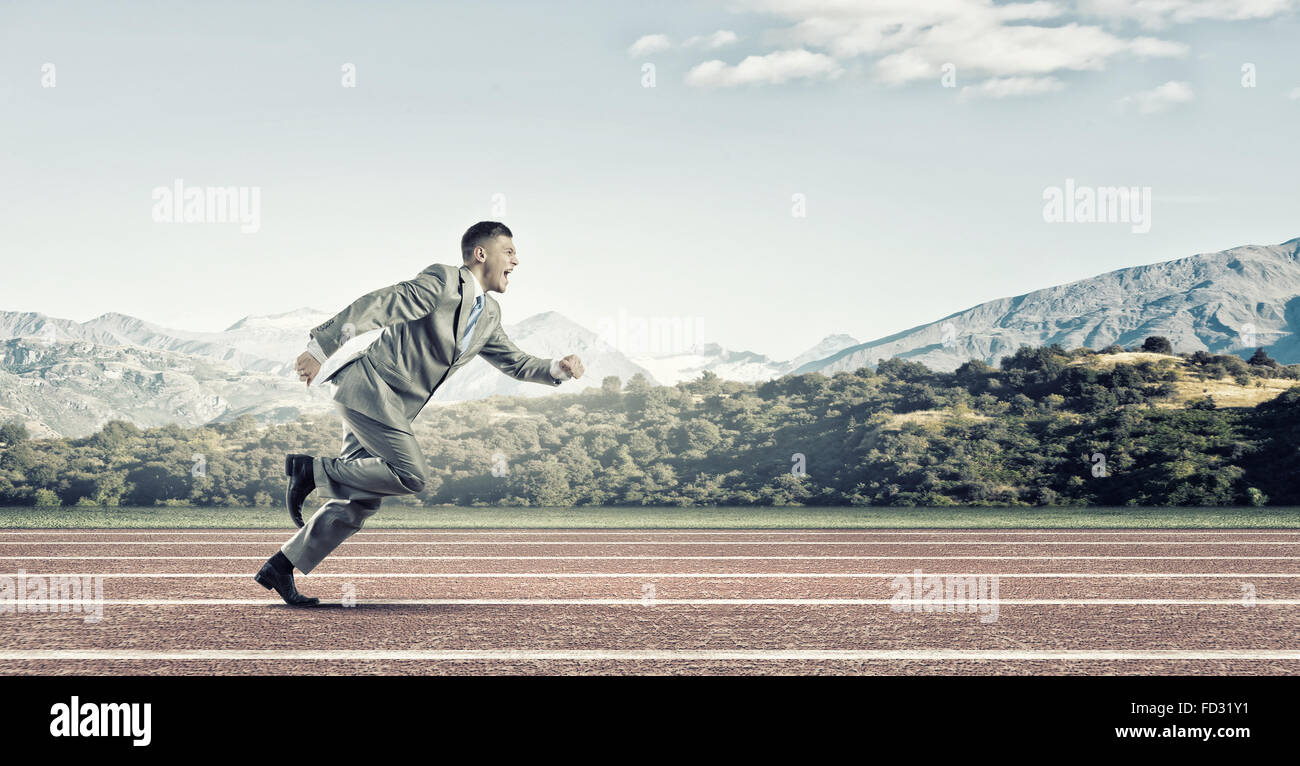 Young businessman in suit running on stadium track Stock Photo - Alamy