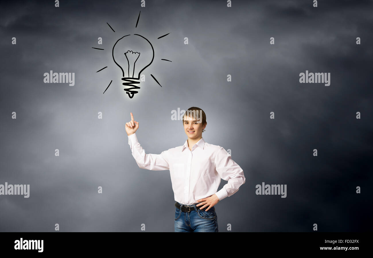 Smiling school boy pointing at light bulb with finger Stock Photo - Alamy