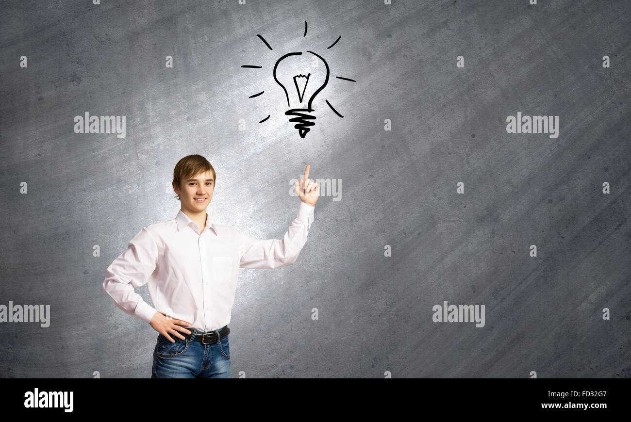 Smiling school boy pointing at light bulb with finger Stock Photo - Alamy