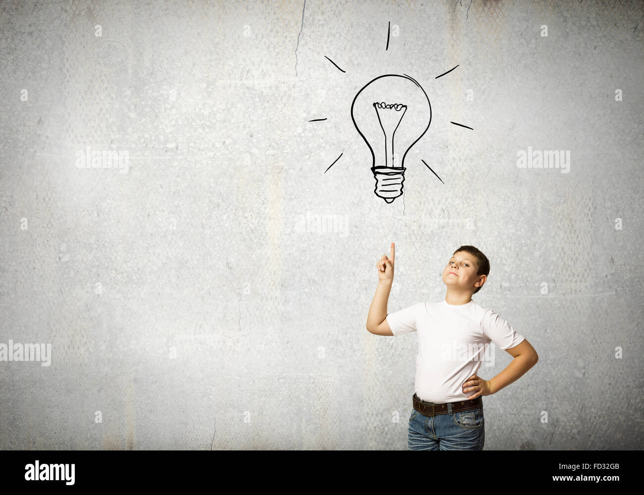Smiling school boy pointing at light bulb with finger Stock Photo - Alamy