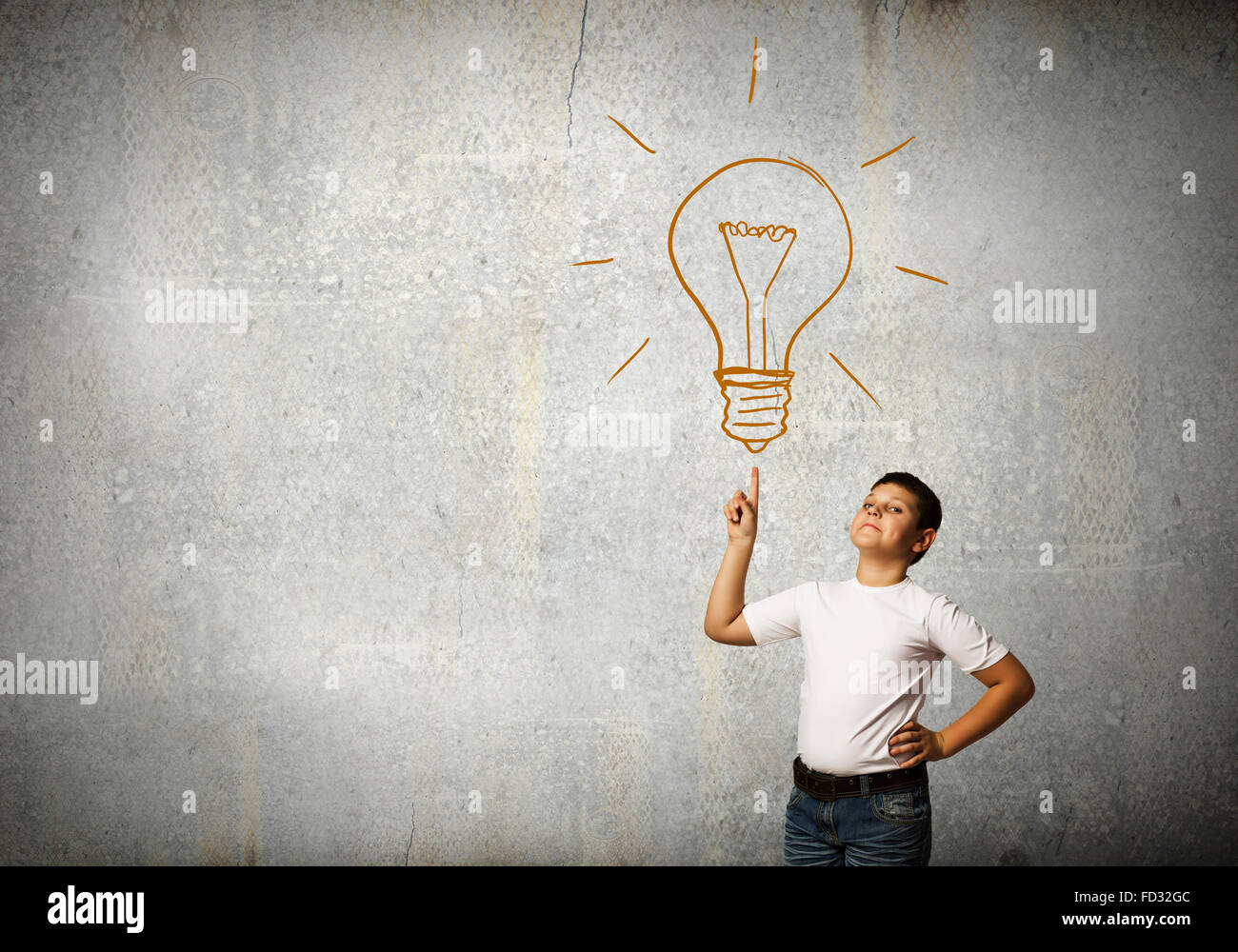Smiling school boy pointing at light bulb with finger Stock Photo - Alamy
