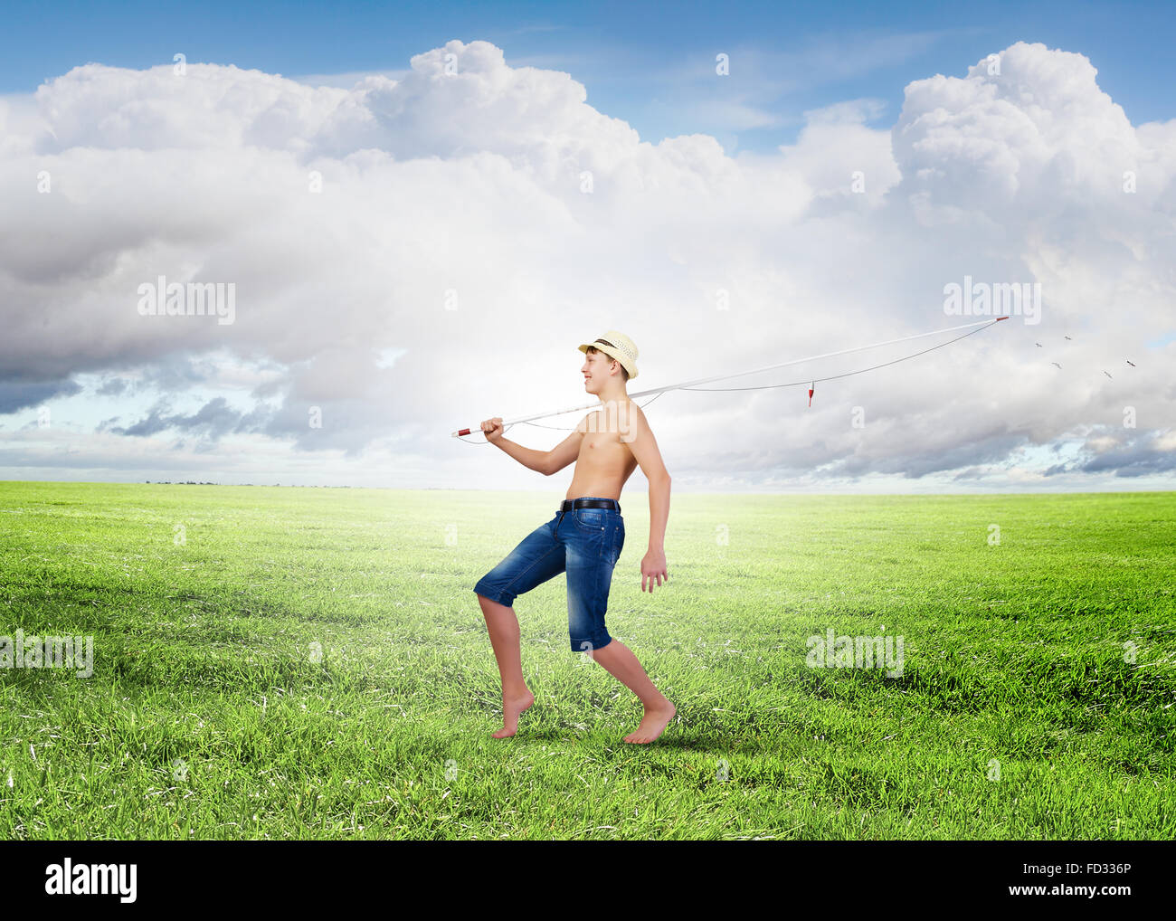 Young boy walking with fishing rod on shoulder Stock Photo - Alamy