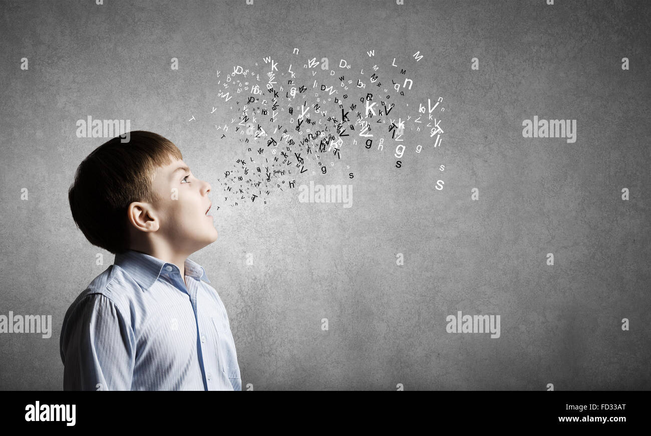 Cute boy of school age and letters flying around Stock Photo - Alamy