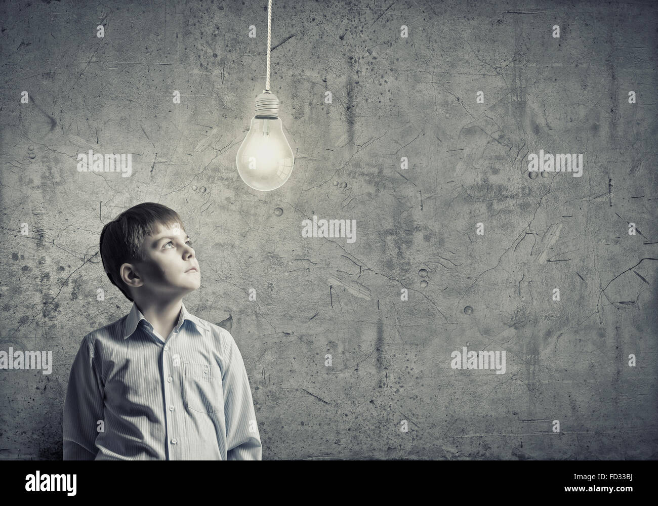 Young boy of school age looking up at light bulb Stock Photo - Alamy
