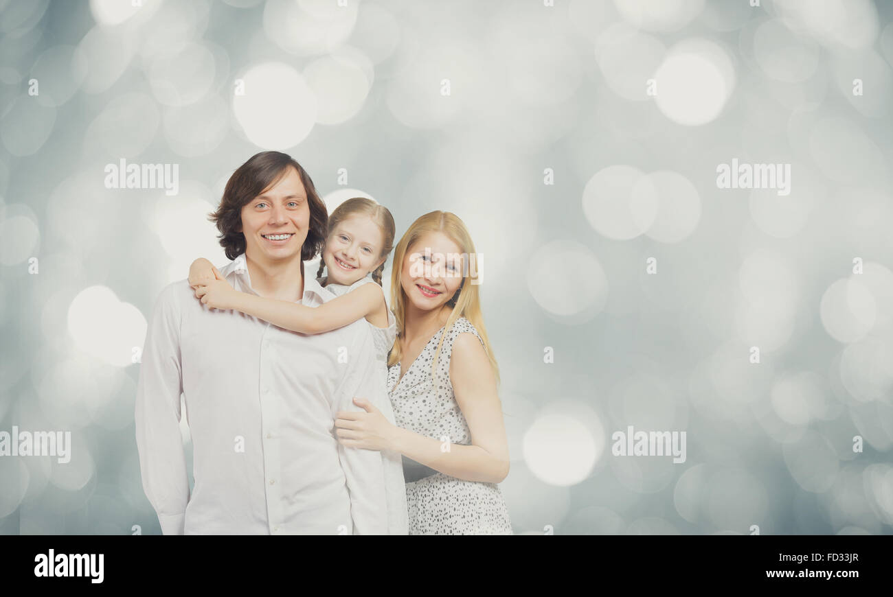 Happy family of mother father and daughter against bokeh background ...