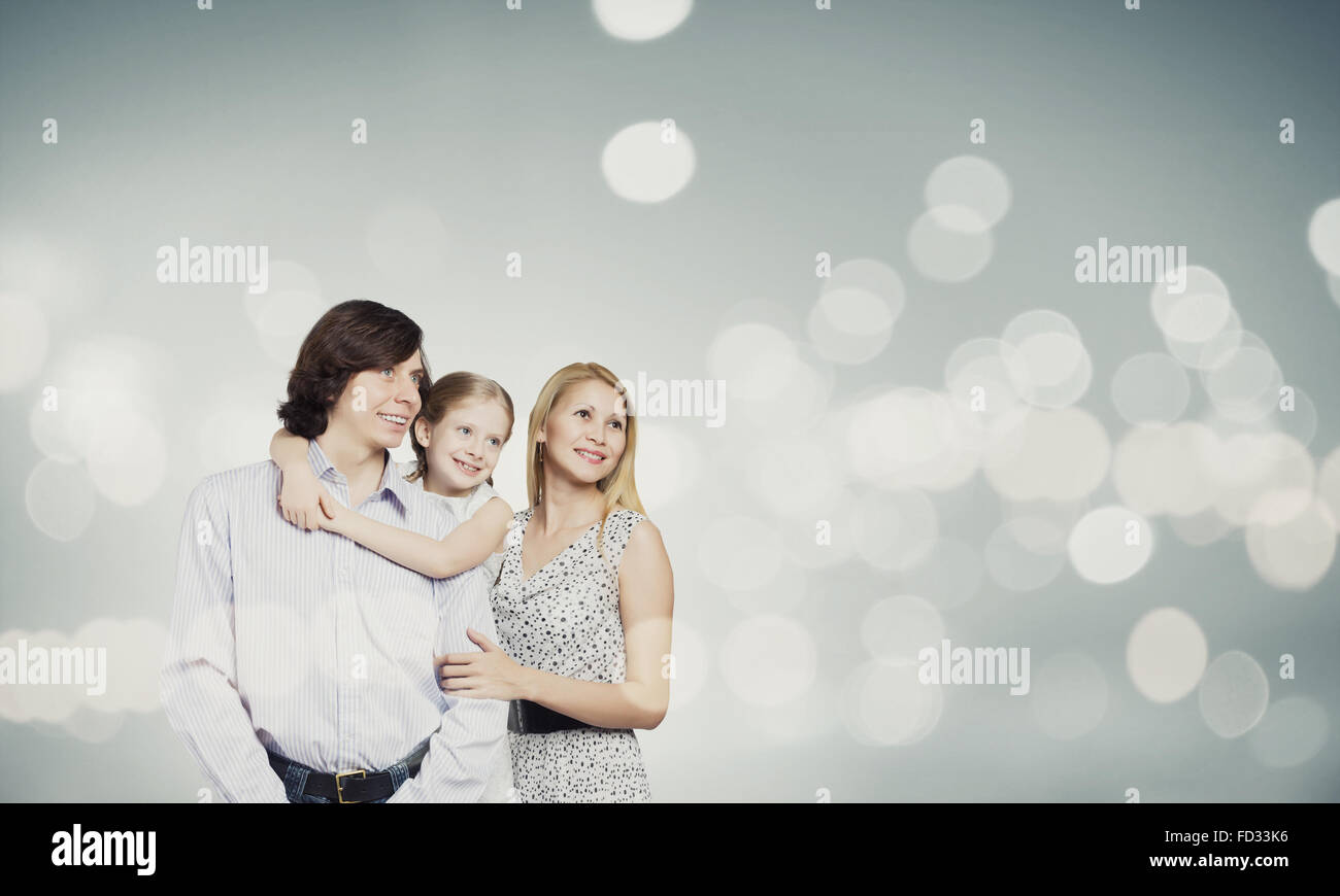 Happy family of mother father and daughter against bokeh background ...