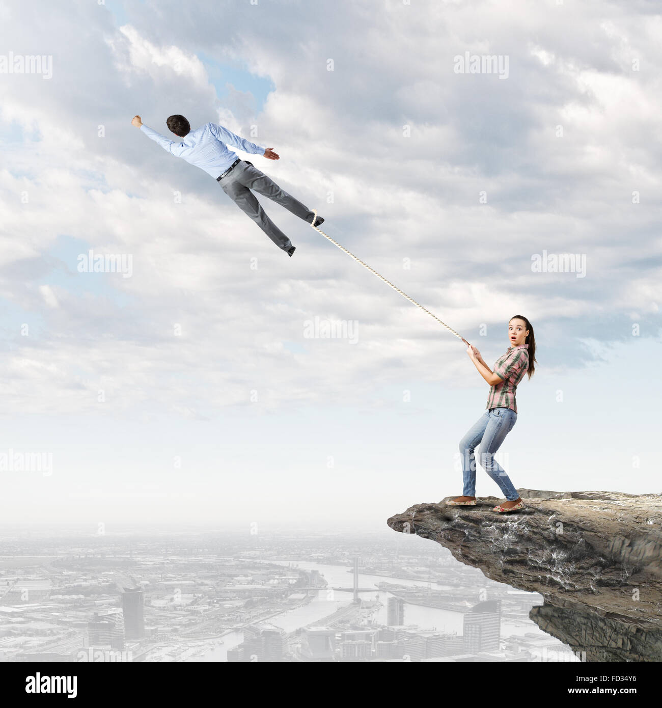 Woman holding on rope businessman trying to escape Stock Photo - Alamy