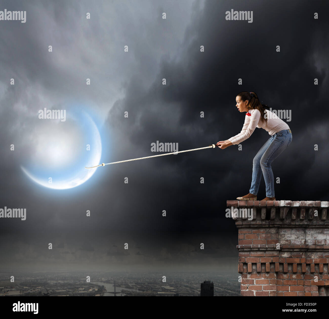 Young woman in casual catching moon with rope Stock Photo - Alamy