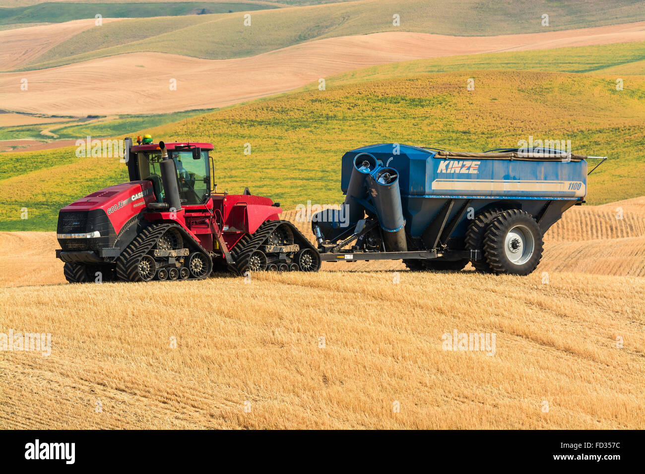 Case quadtrac tractor pulling a grain cart in a wheat field during ...
