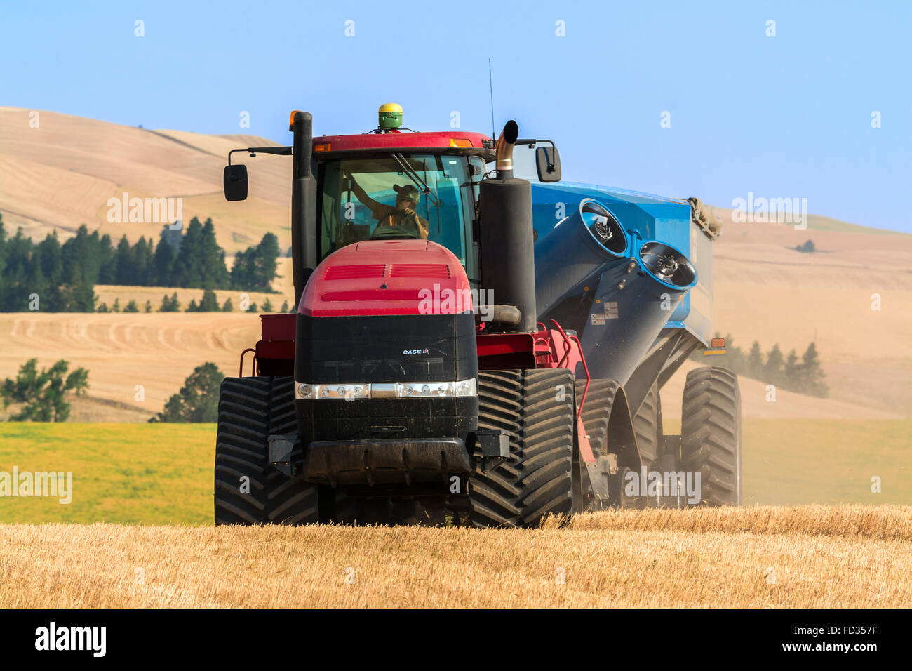 Case quadtrac tractor pulling a grain cart in a wheat field during ...