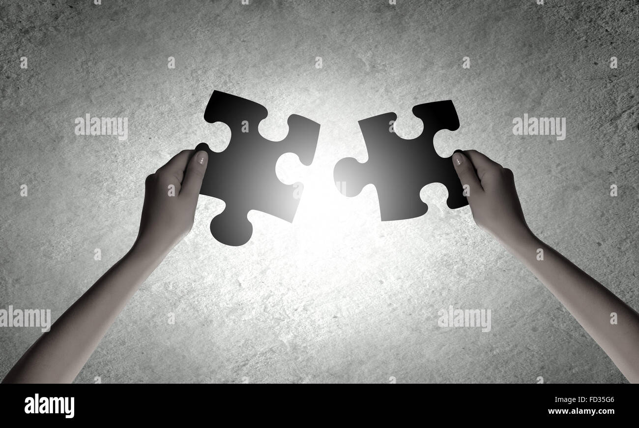 Close up of human hands connecting puzzle elements Stock Photo - Alamy