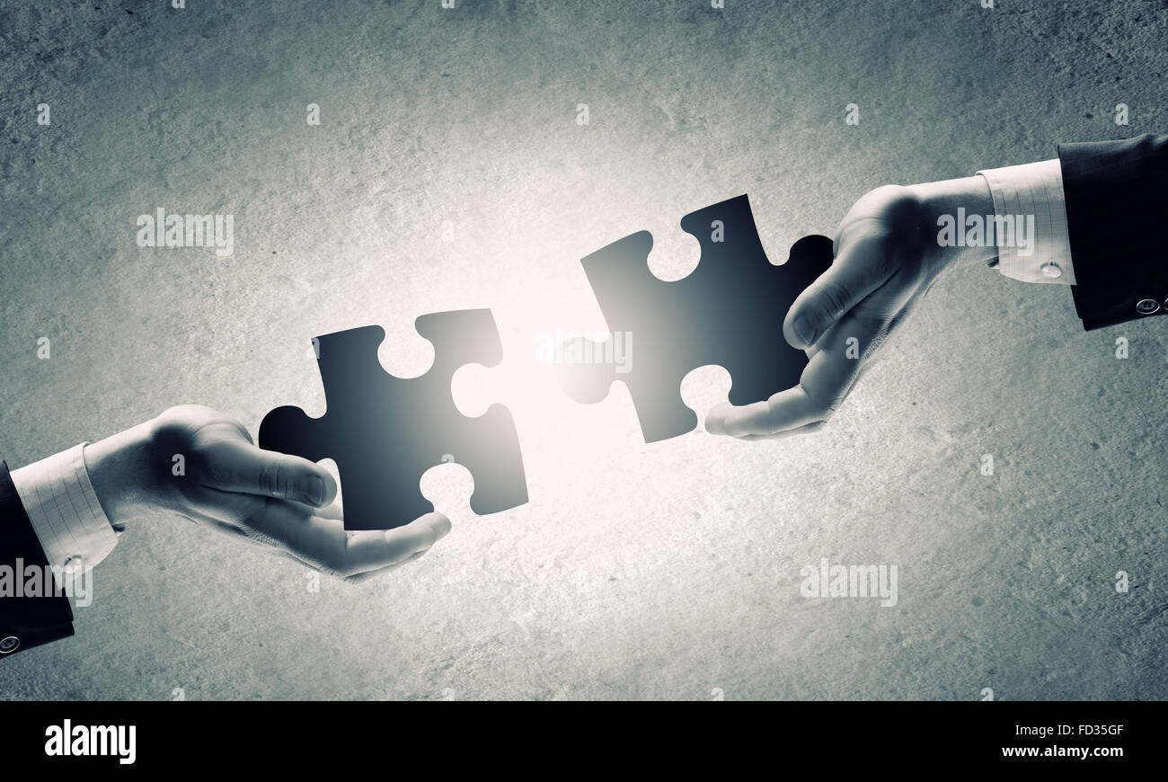 Close up of human hands connecting puzzle elements Stock Photo - Alamy