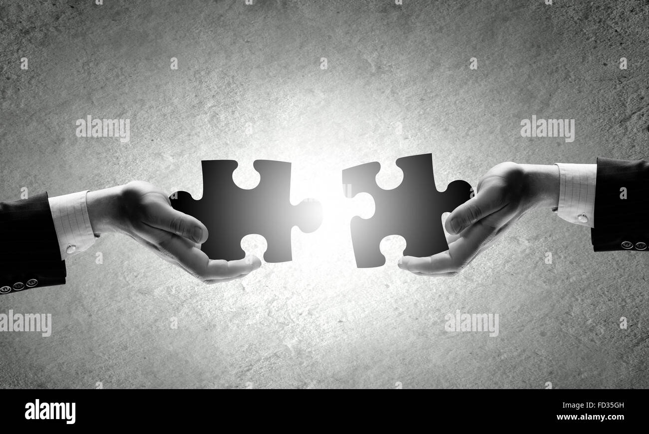 Close up of human hands connecting puzzle elements Stock Photo - Alamy