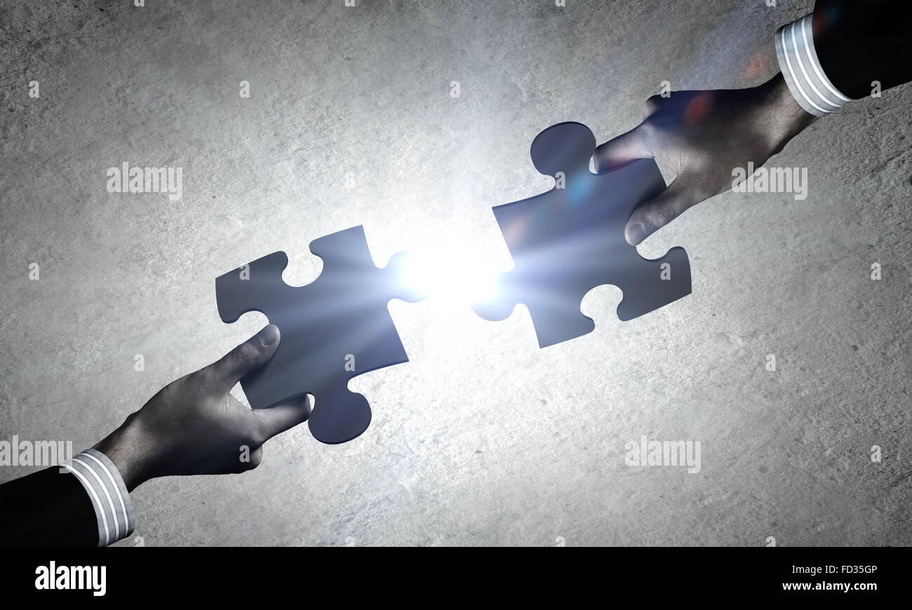 Close up of human hands connecting puzzle elements Stock Photo - Alamy