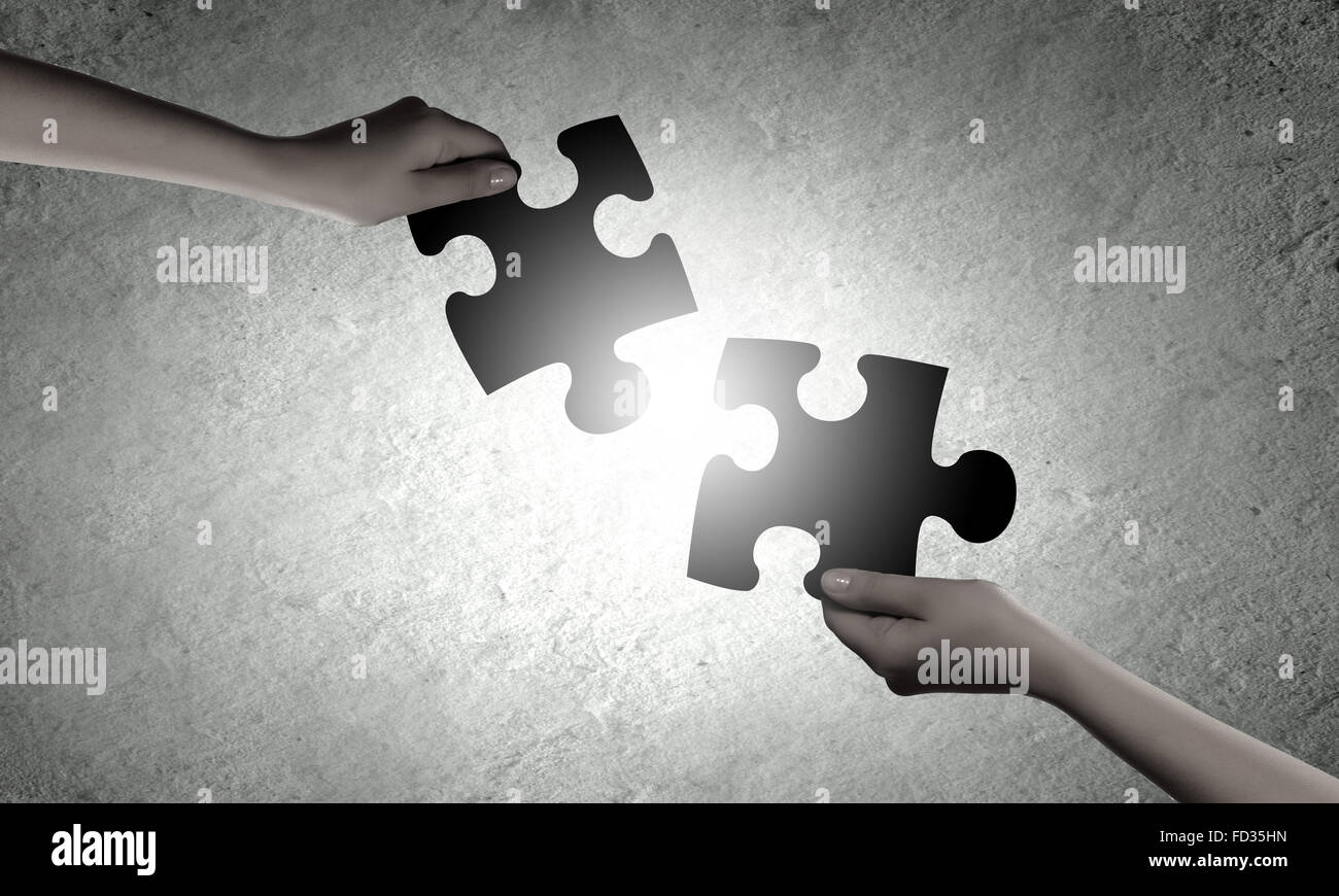 Close up of human hands connecting puzzle elements Stock Photo - Alamy
