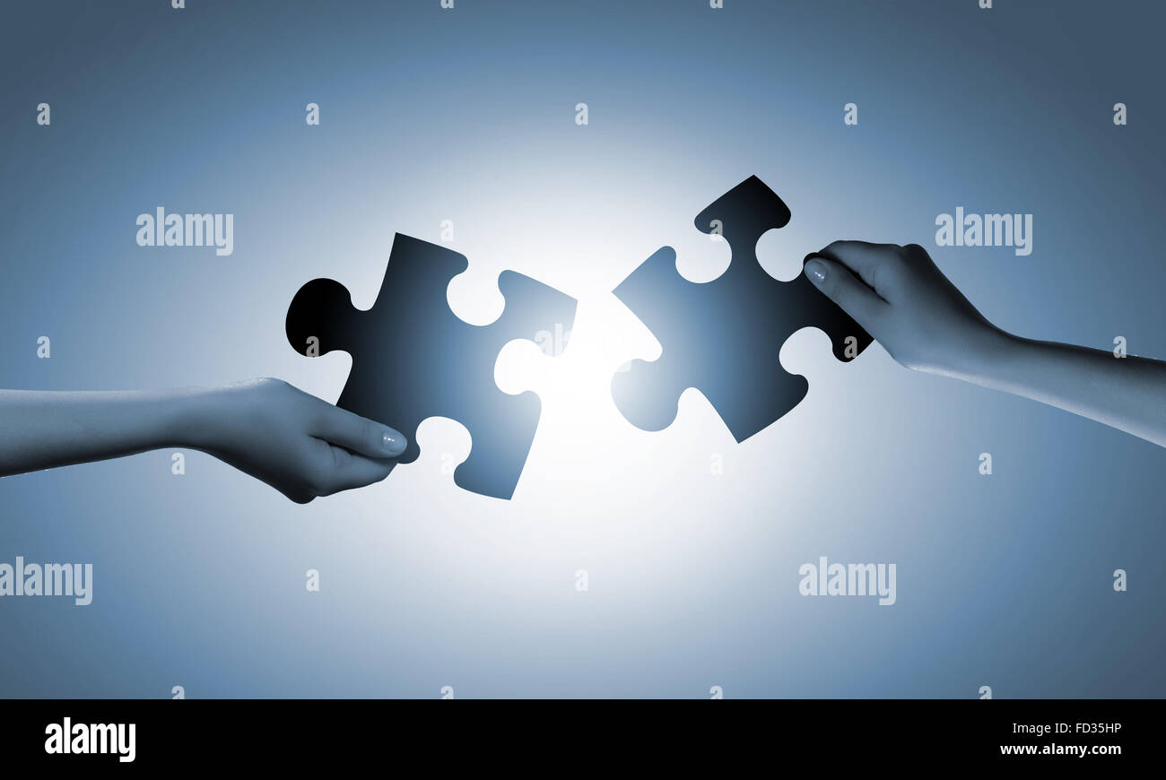 Close up of human hands connecting puzzle elements Stock Photo - Alamy