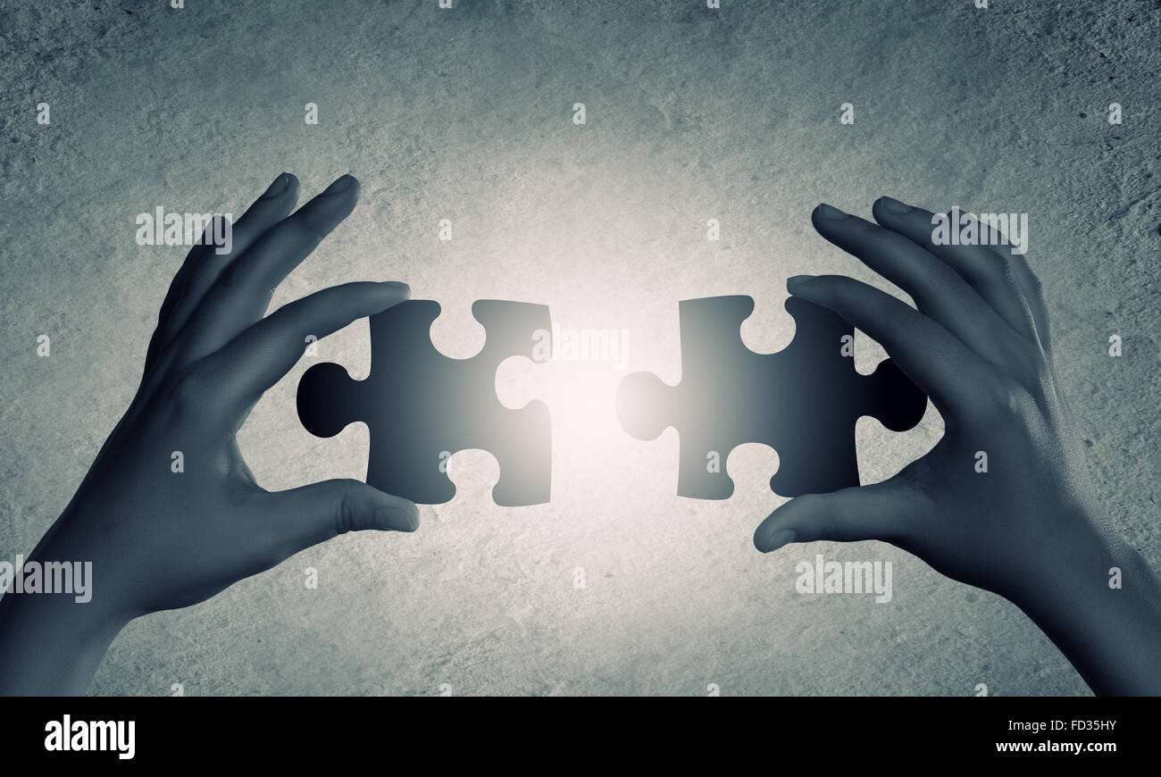 Close up of human hands connecting puzzle elements Stock Photo - Alamy