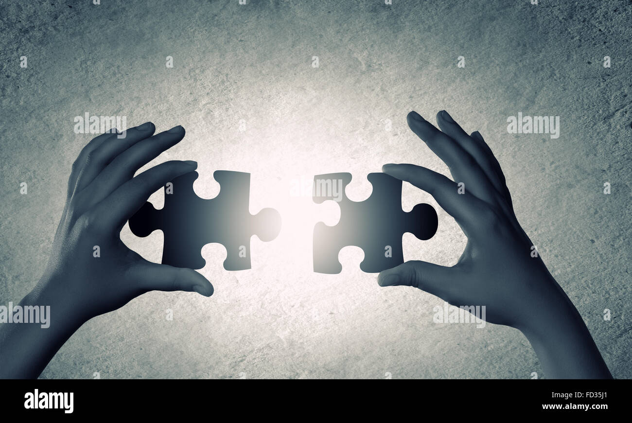 Close up of human hands connecting puzzle elements Stock Photo - Alamy