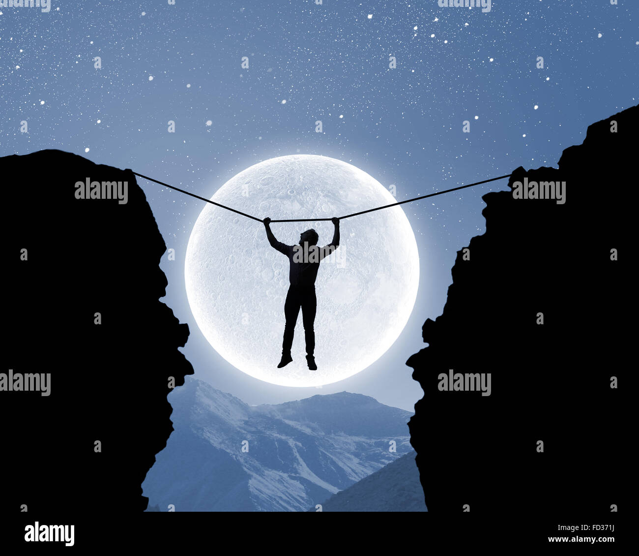 Silhouette of man hanging on rope above gap Stock Photo - Alamy
