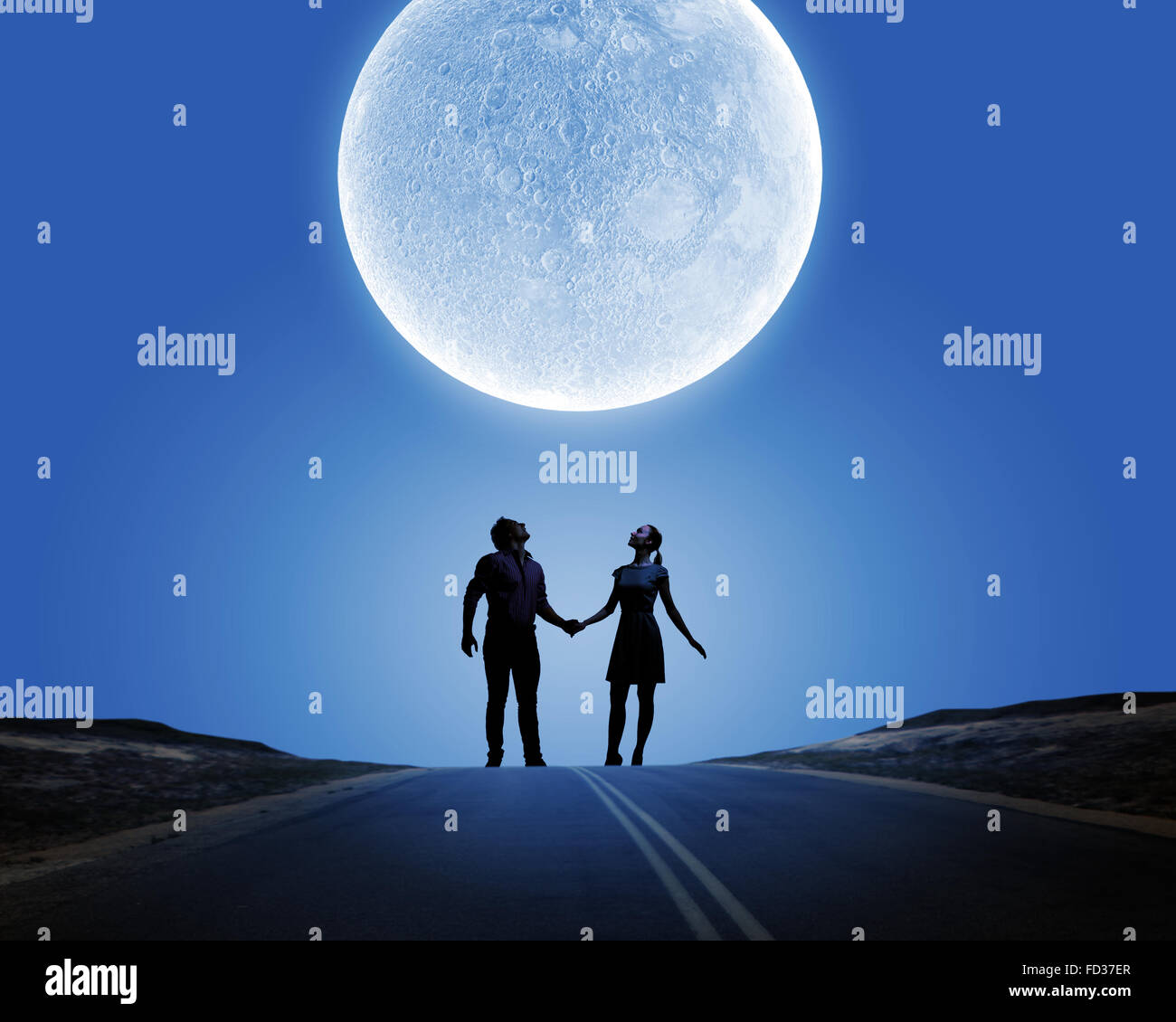 Silhouettes of young romantic couple standing under the moon light ...