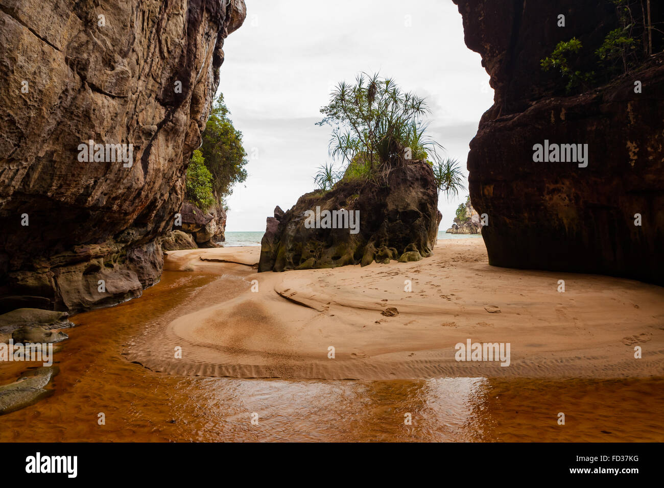 Tropical beach between two big rocks Stock Photo - Alamy