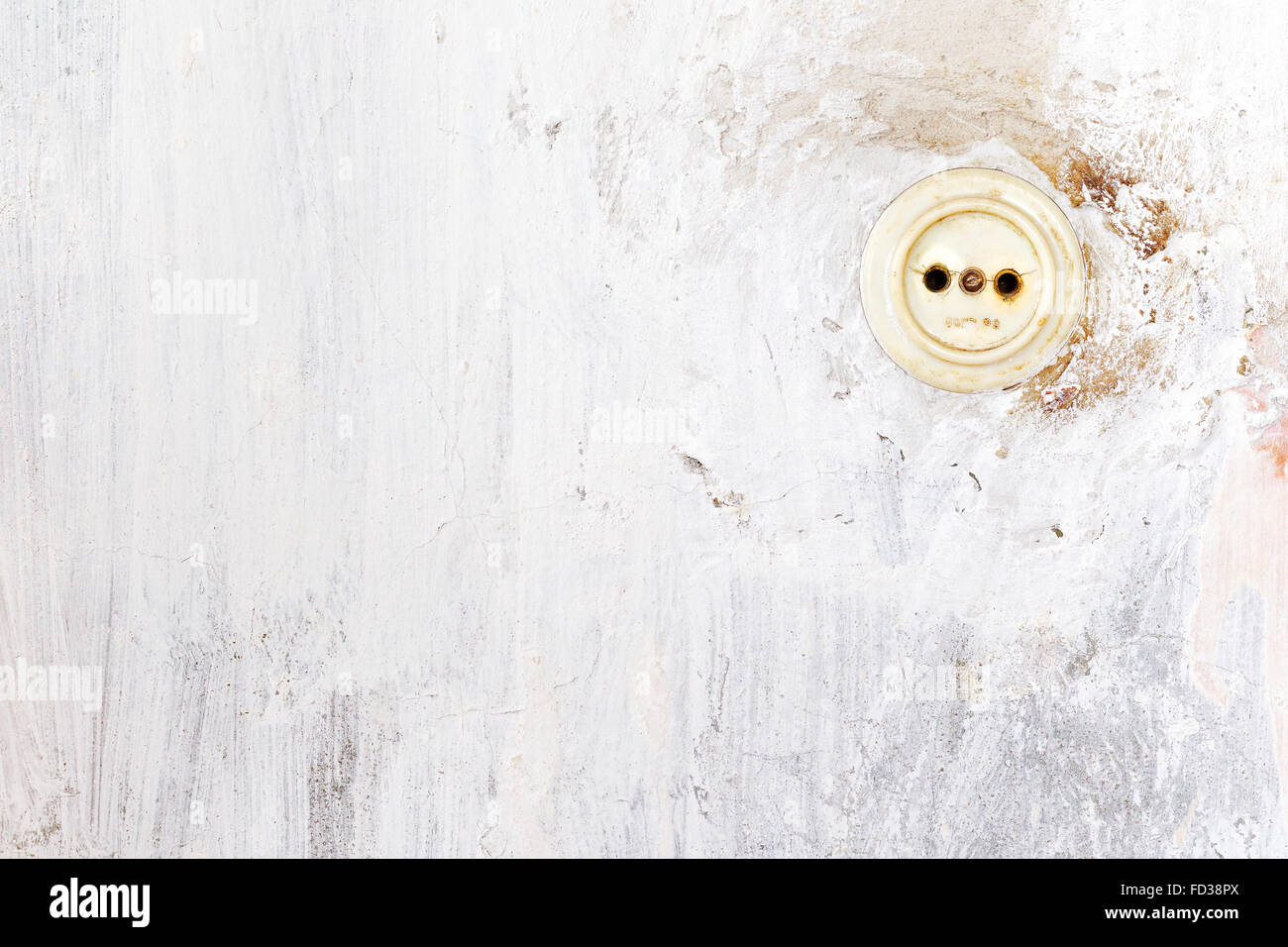 Vintage electrical outlet in the old plastered wall with cracks and ...