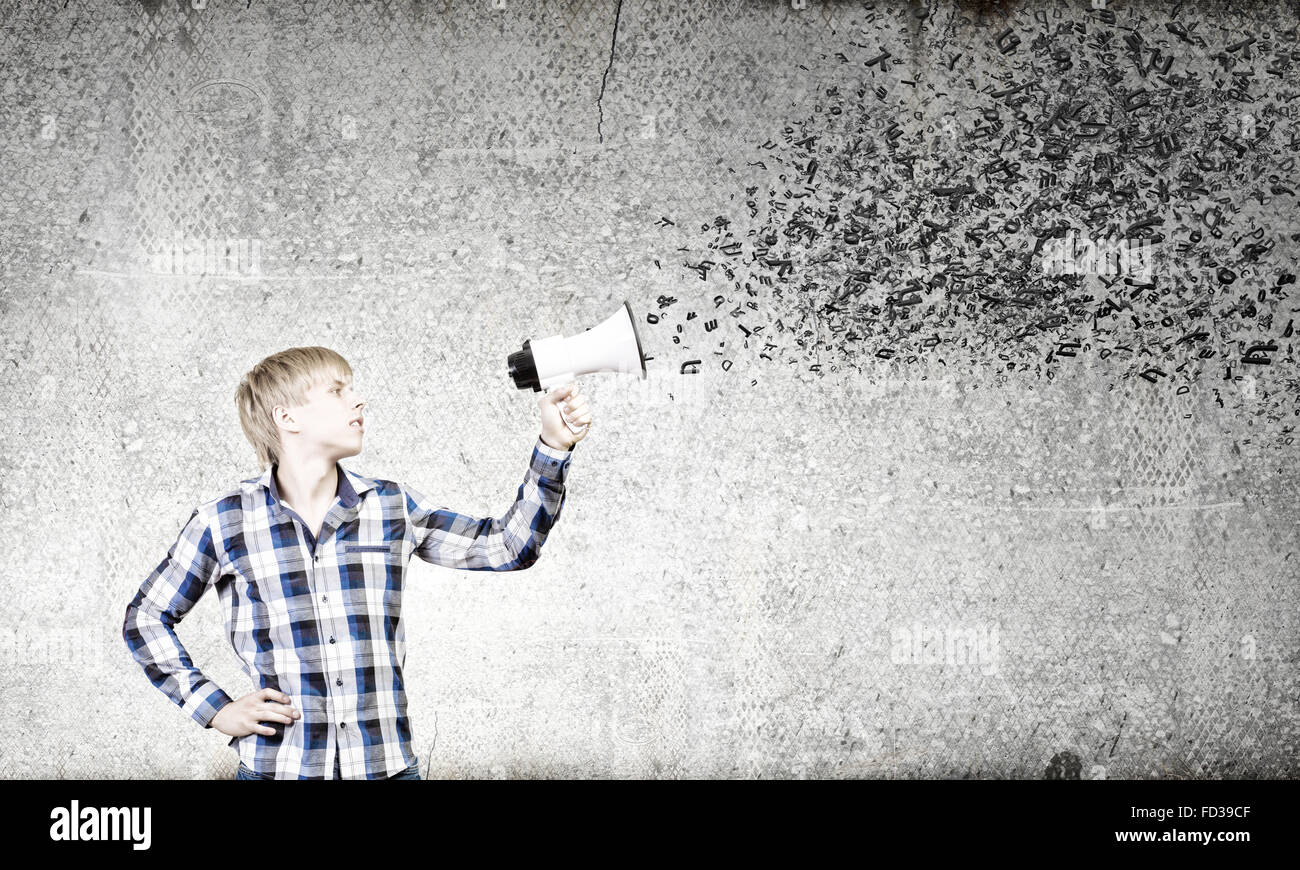 Young man in casual announcing something in megaphone Stock Photo - Alamy