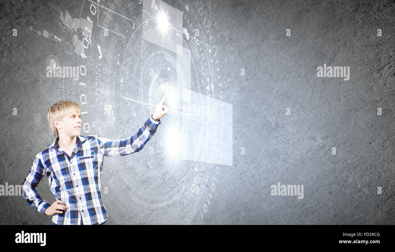 Young man in casual touching icon of media screen Stock Photo - Alamy