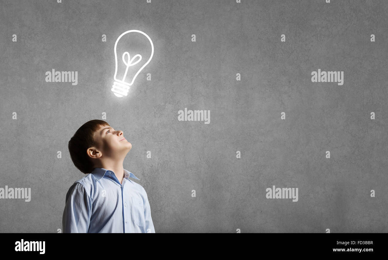 Young boy of school age looking up at light bulb Stock Photo - Alamy