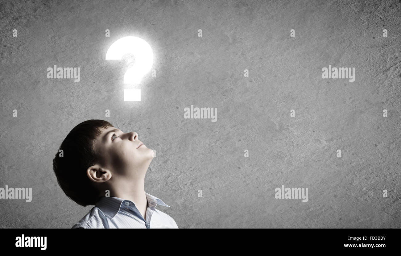 Young boy of school age looking question mark Stock Photo - Alamy