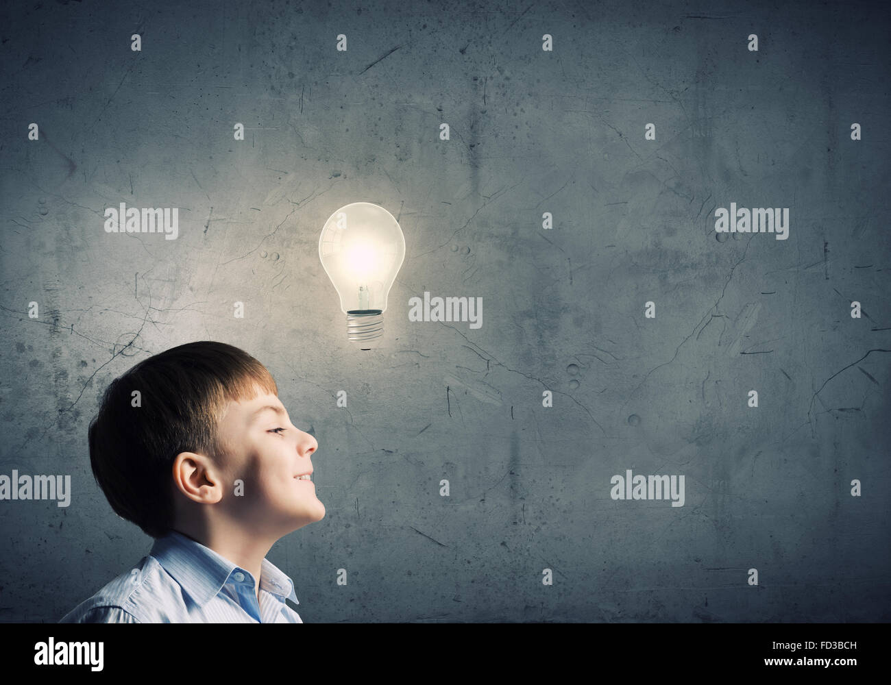 Young boy of school age looking up at light bulb Stock Photo - Alamy