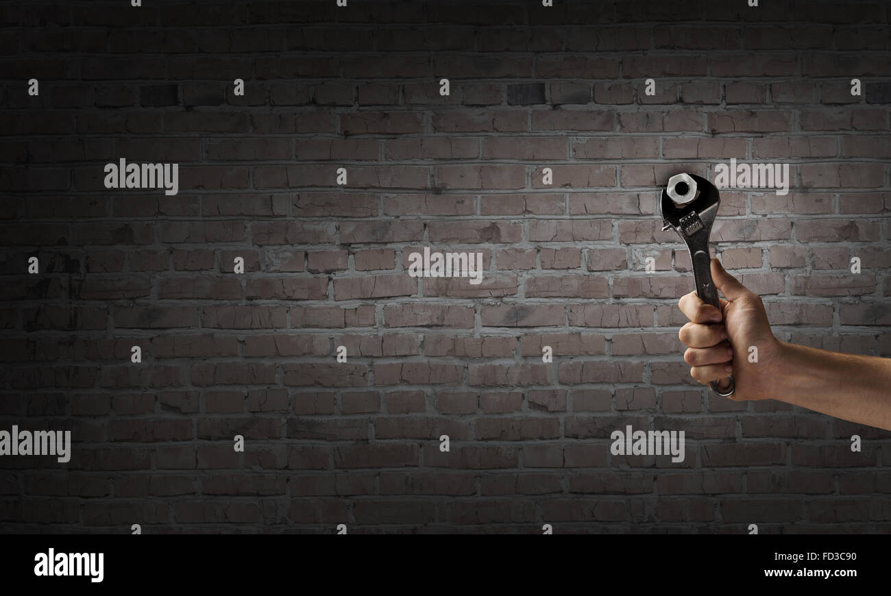 Close up of hand spinning nut with wrench Stock Photo - Alamy