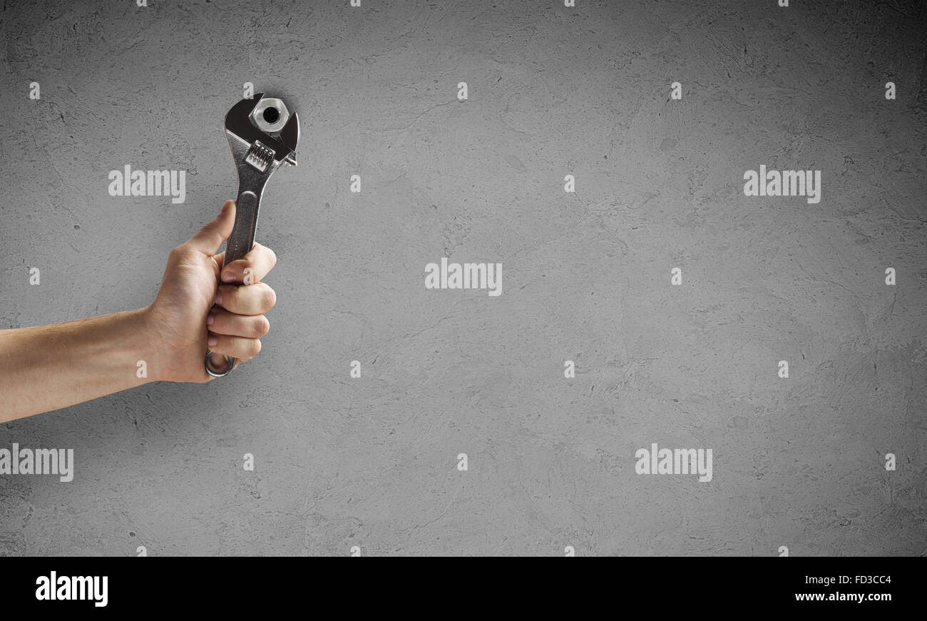 Close up of hand spinning nut with wrench Stock Photo - Alamy