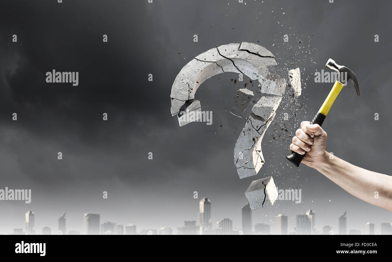 Close up of hammer in human hand breaking stone question mark Stock ...