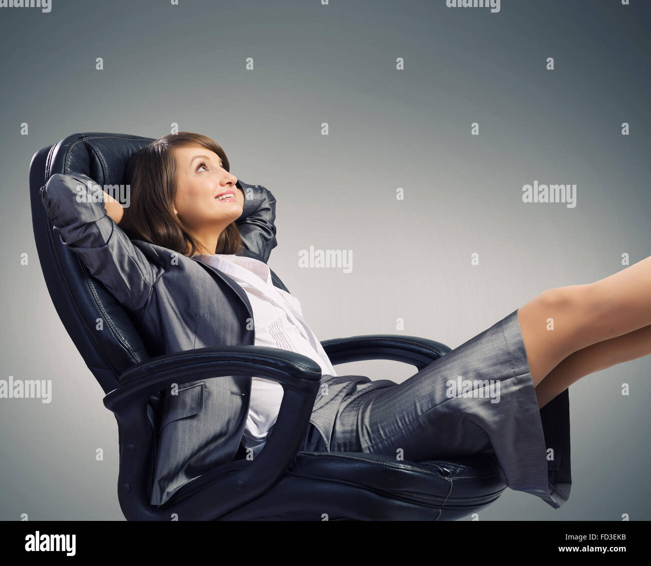 Young confident businesswoman sitting in chair with legs up Stock Photo ...