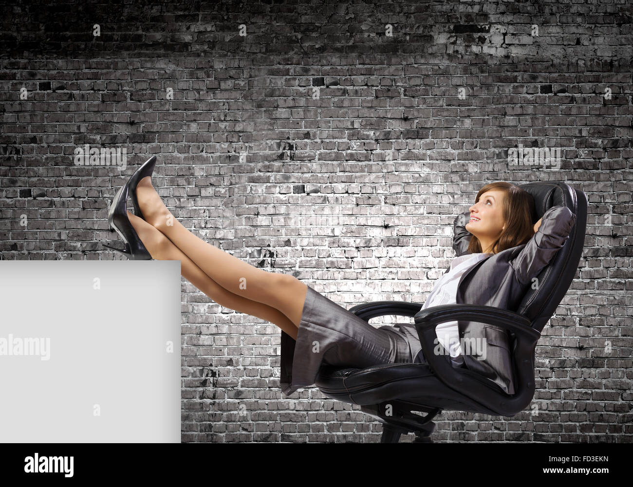 Young confident businesswoman sitting in chair with legs up Stock Photo ...