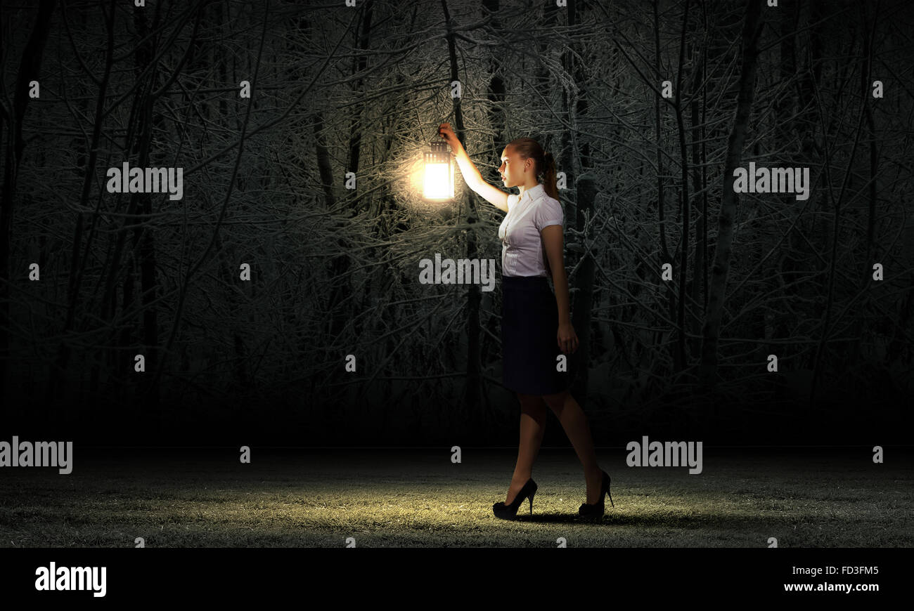 Young businesswoman walking in darkness with lantern in hand Stock ...