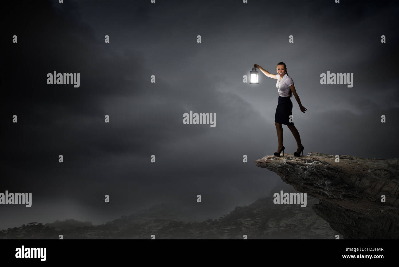 Young businesswoman walking in darkness with lantern in hand Stock ...