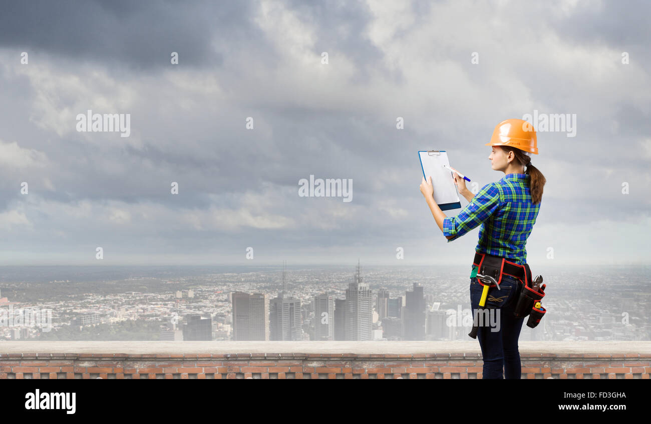 Rear view of woman engineer making some notes and sketches Stock Photo ...