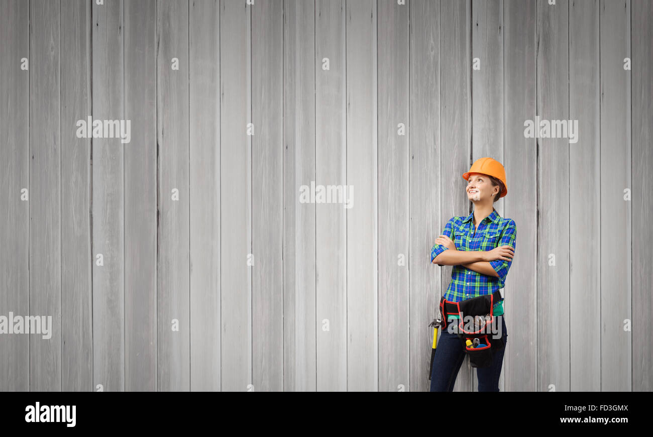 Attractive smiling woman engineer wearing helmet and tool belt Stock ...