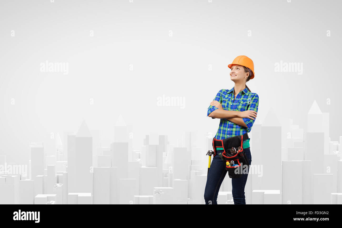 Attractive smiling woman engineer wearing helmet and tool belt Stock ...
